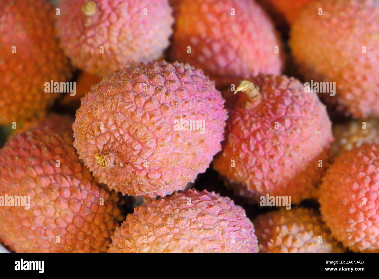 Close-up of a heap of pink lychee Stock Photo - Alamy
