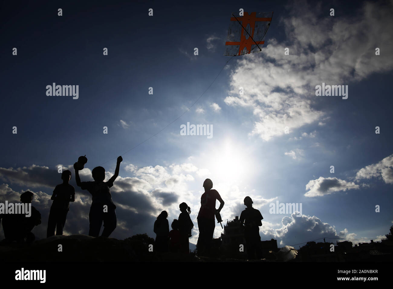 Kathmandu, Nepal. 21st Sep, 2019. Boys silhouetted fly kites ahead of ...
