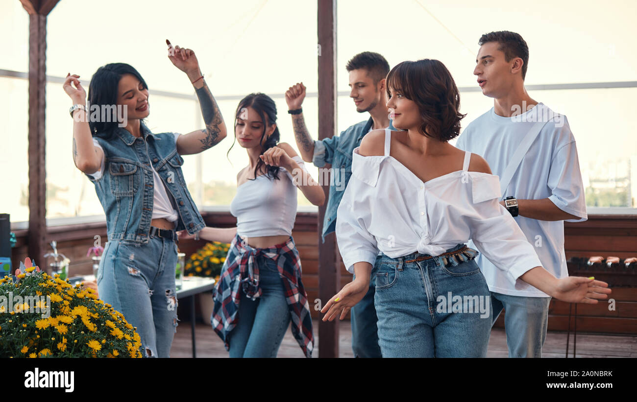 Let's dance Group of happy friends enjoying party on rooftop terrace ...