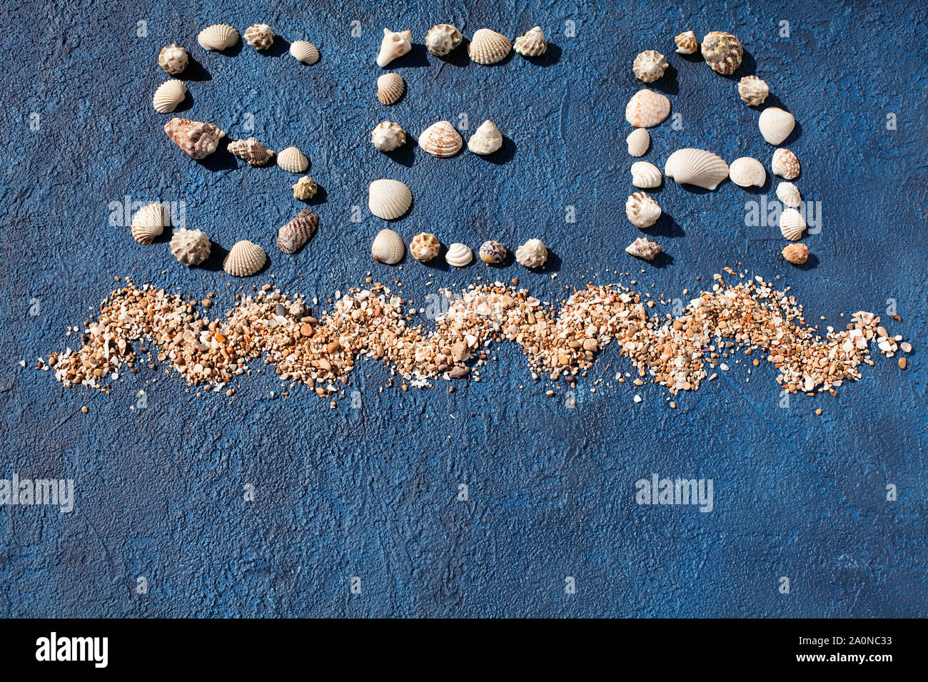 Word sea made of seashells, decorative ocean wave, golden sand on blue ...