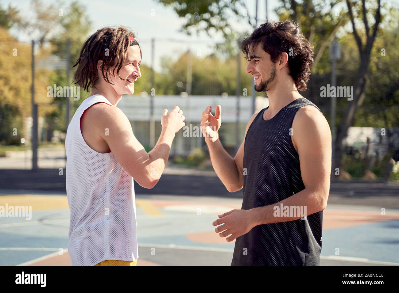 Picture of happy two athletes men shaking hands on sports field on ...