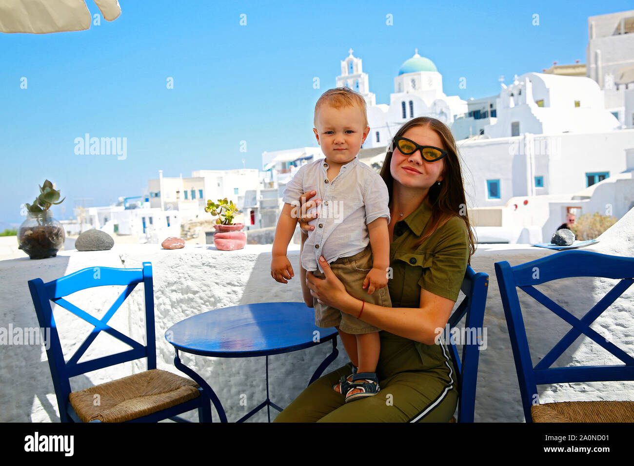 Woman with a child on the background of the architecture of Santorini ...