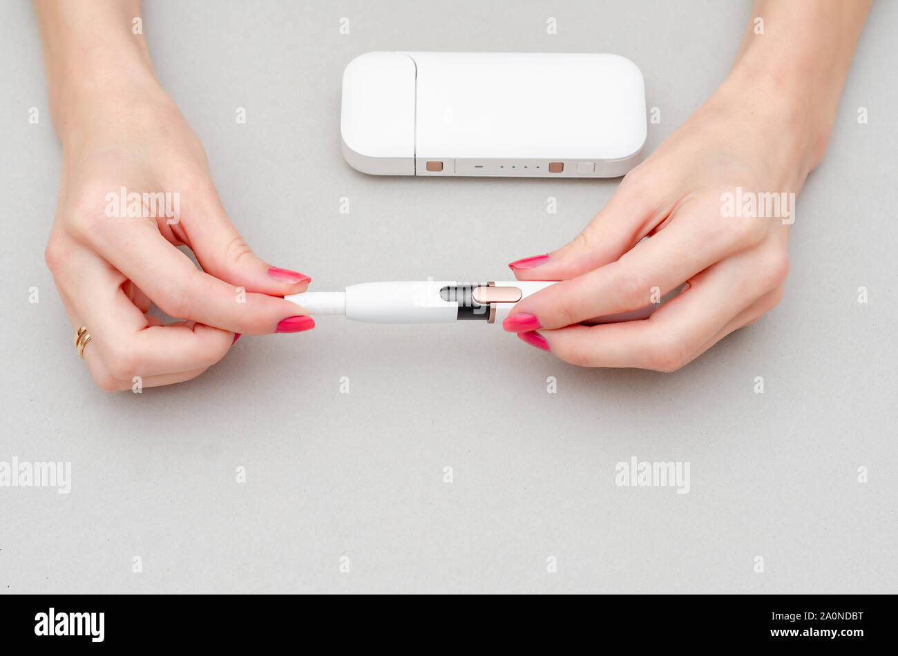 Woman's hands holds an electronic cigarette. Insert a cigarette into ...