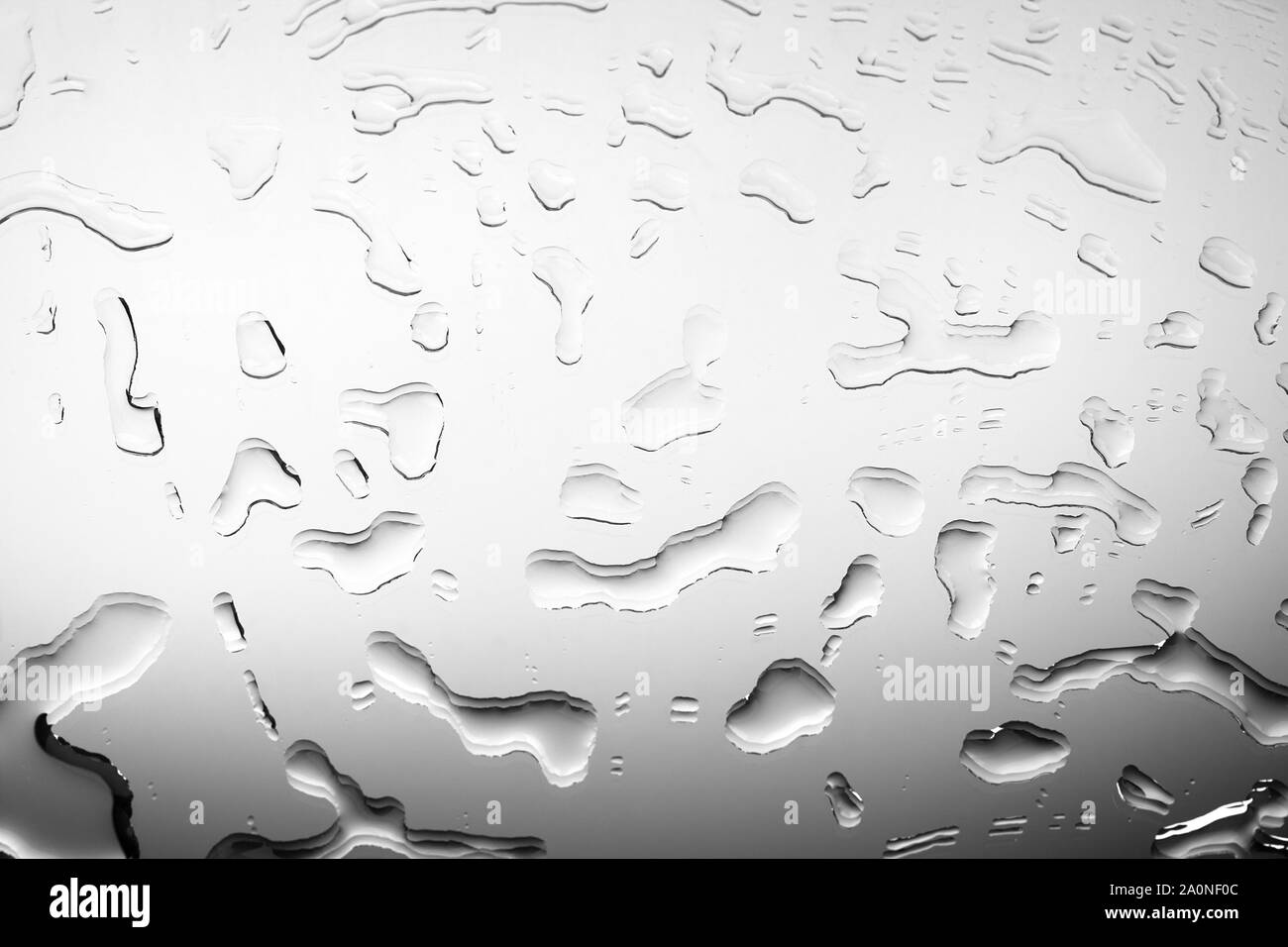 Monochrome black and white image of spilled water, glass surface in ...