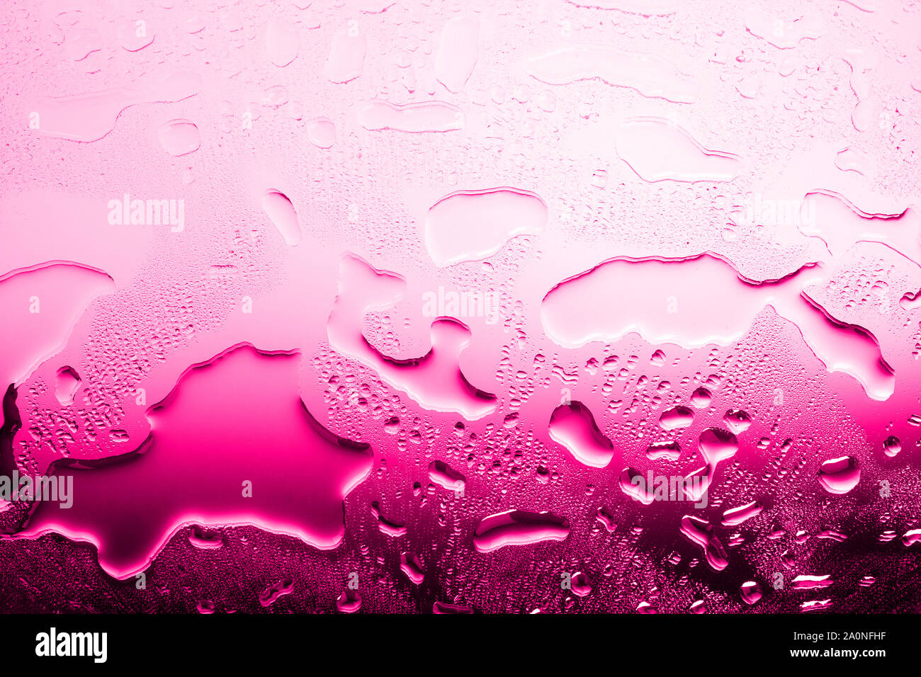 Glass surface in drops of water, bright pink color, shiny drops texture ...