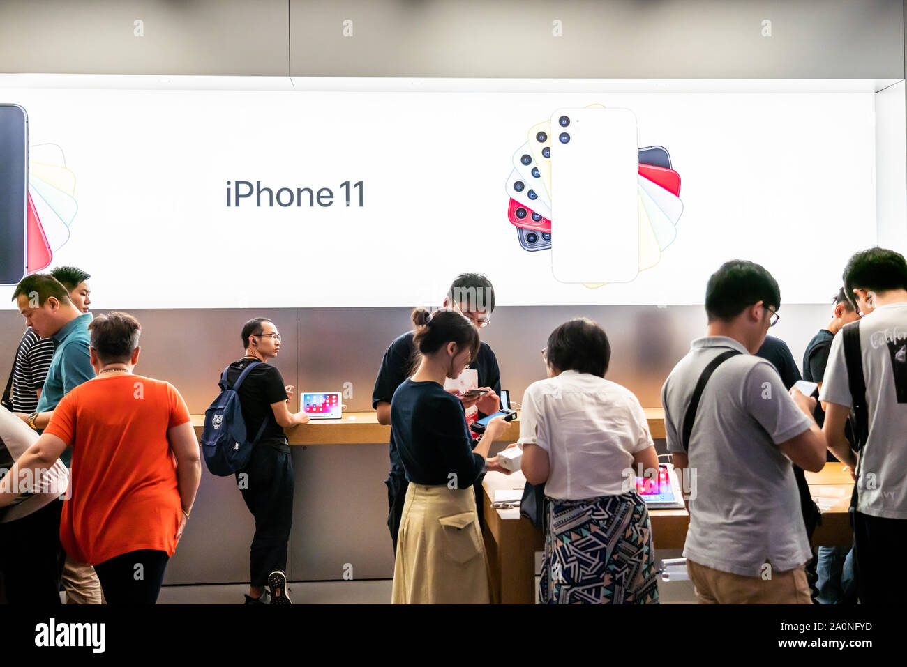 Customers look at the Apple's new iPhone 11 series smartphones at an ...