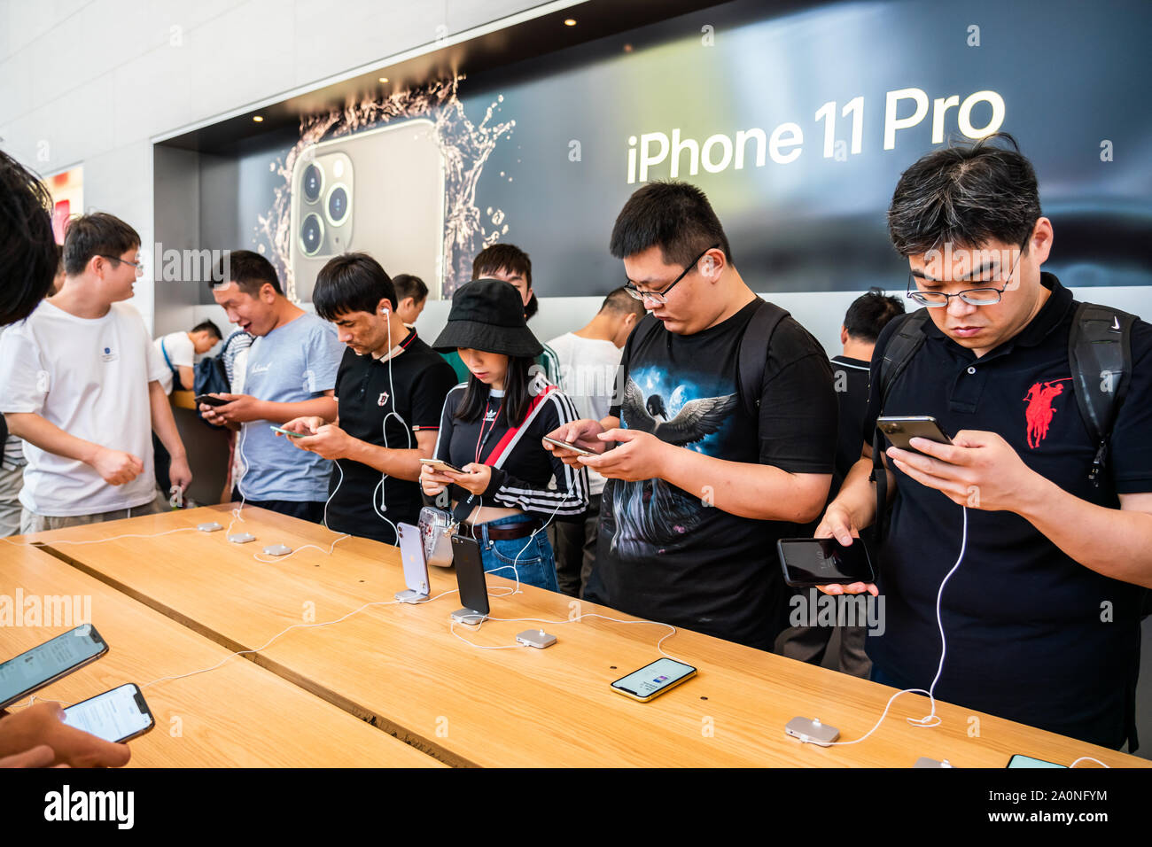 Customers look at the Apple's new iPhone 11 series smartphones in an ...