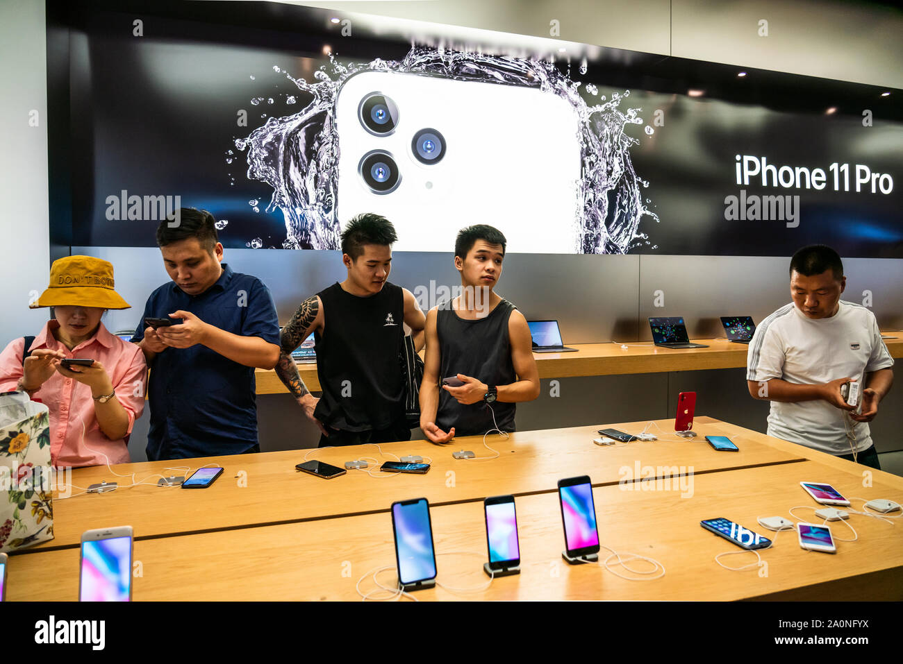 Customers look at the Apple's new iPhone 11 series smartphones in an ...