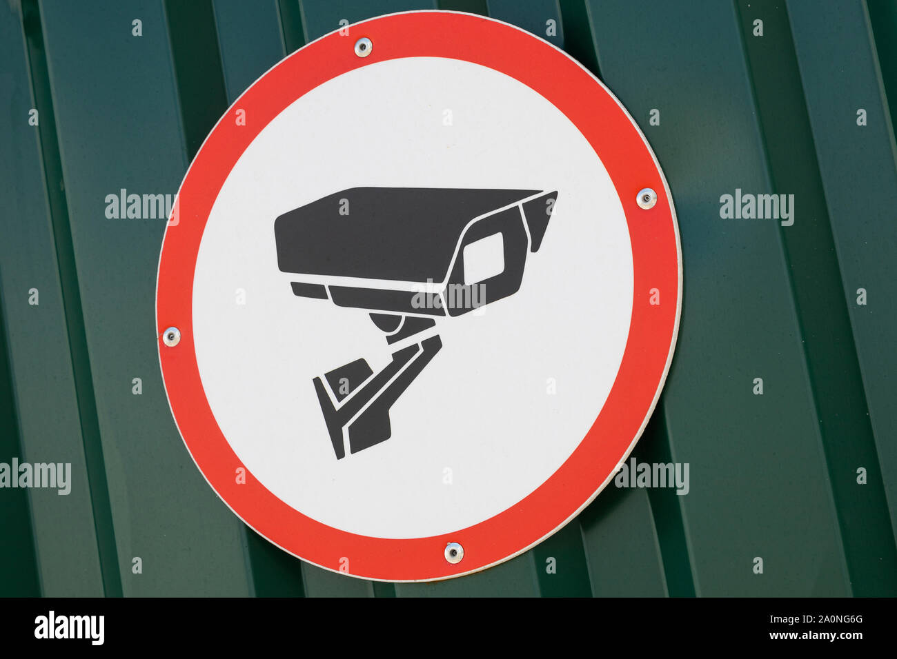 CCTV in operation sign on green corrugated fence background. White and ...