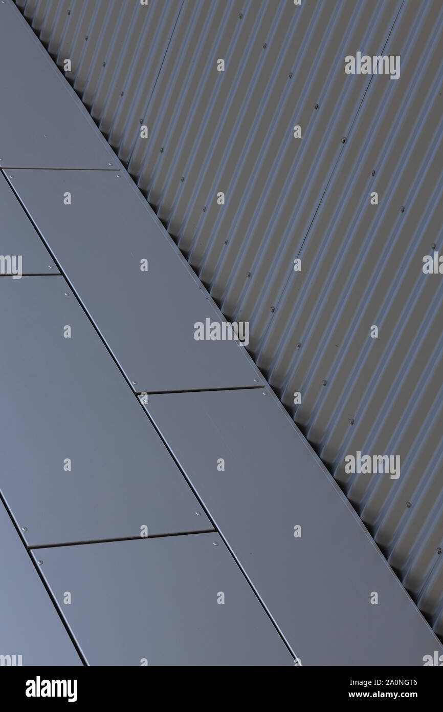 Angular view of corner of building - junction of grey smooth tiled wall ...