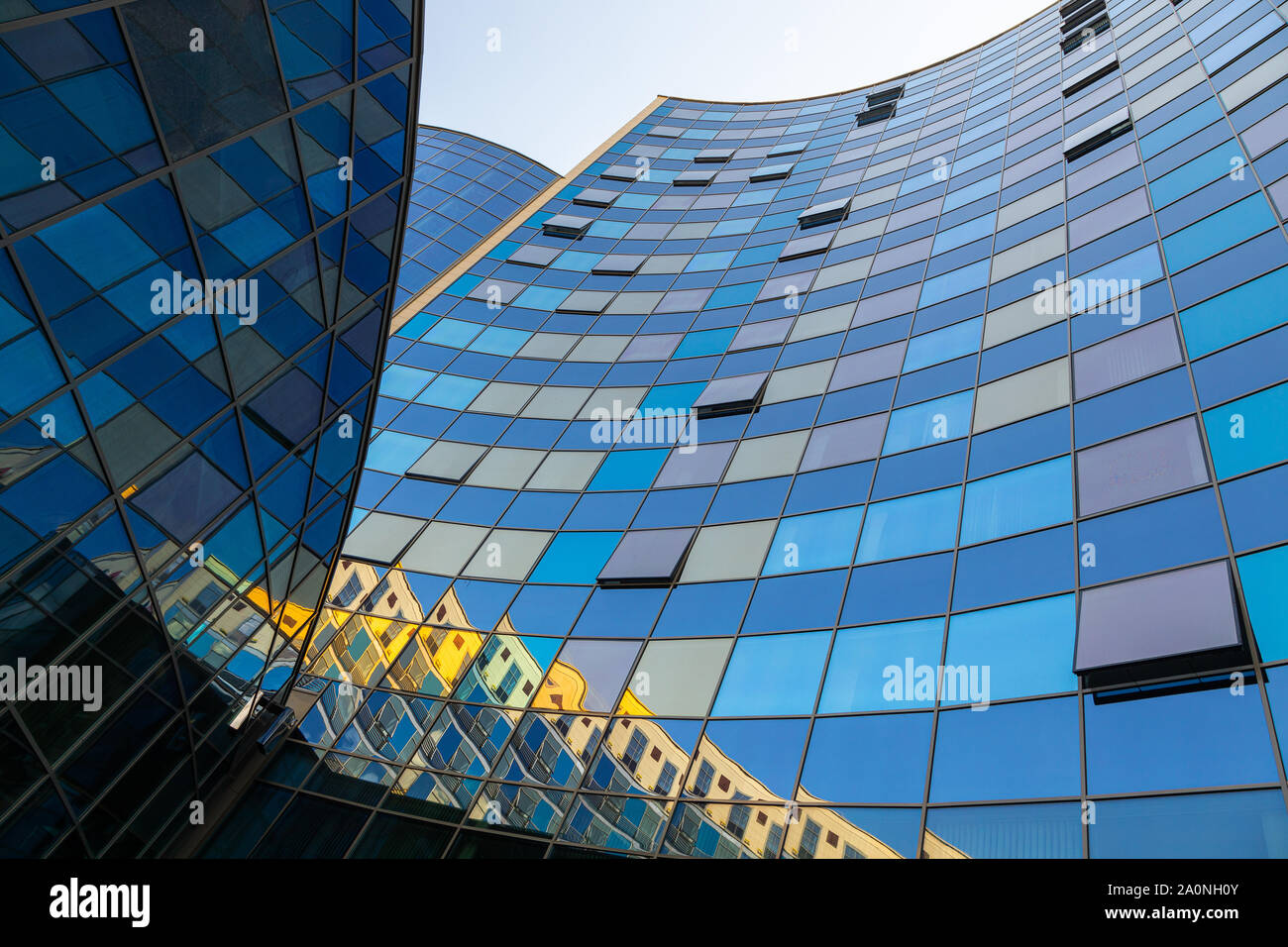 Ground view of blue glass surface of semicircle building wall ...