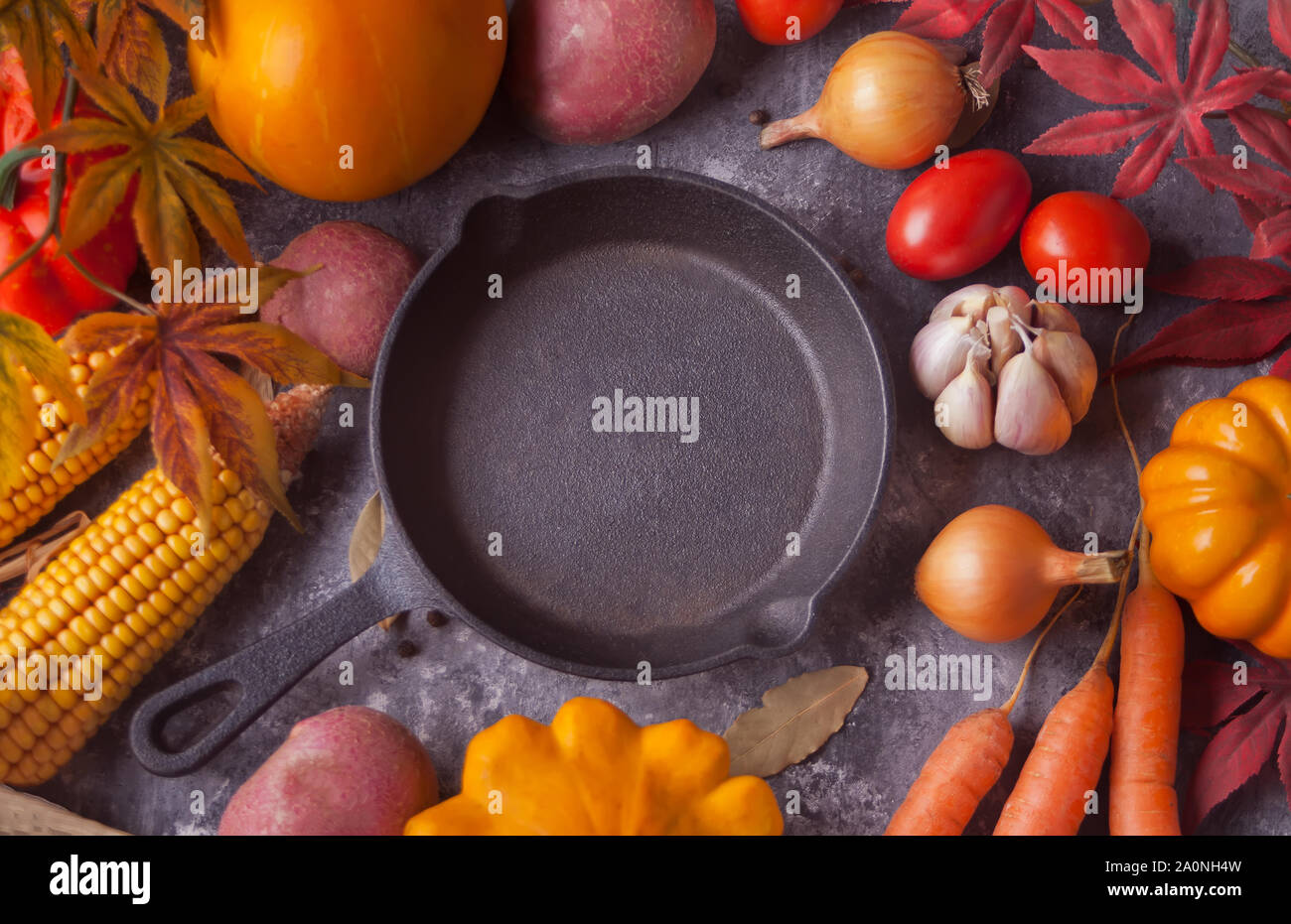 Frying pan, autumn leaves, vegetables on the black background. Autumn ...