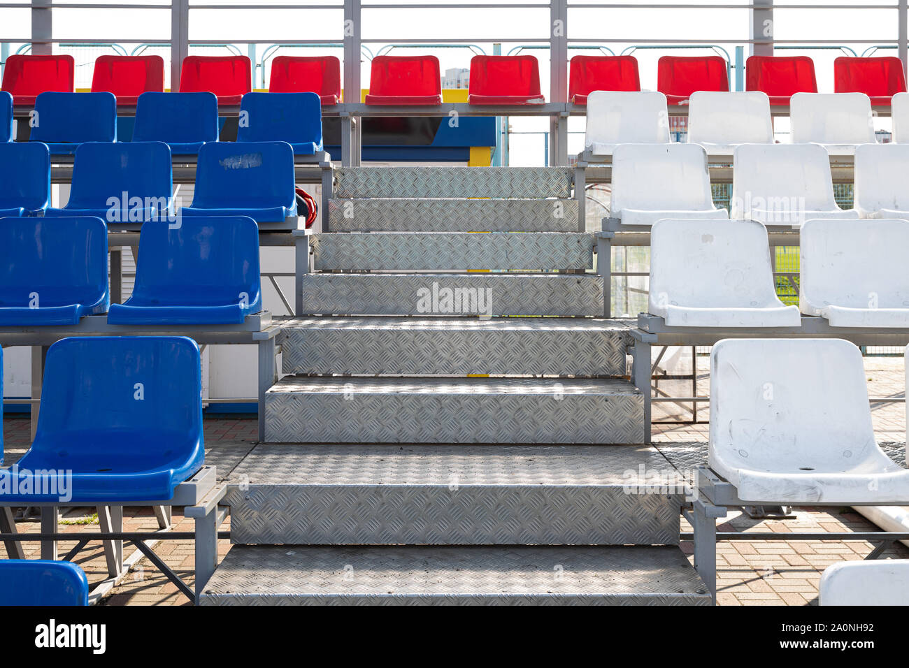 Front view of blue and red plactic seats on sport stadium's tribune ...
