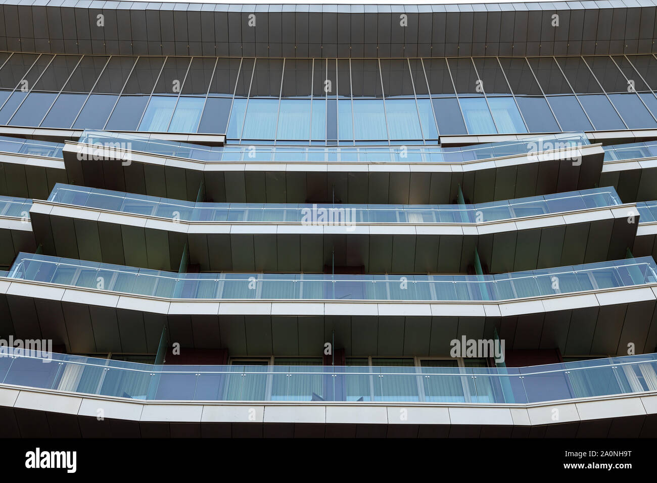 Front view of facade of new modern glass building with balconies Stock ...
