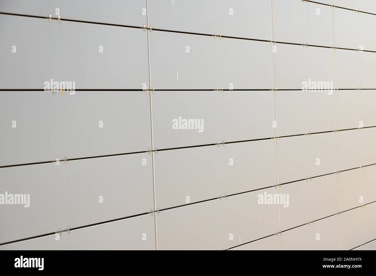 Light grey metal wall of a building made of small metal right angled ...