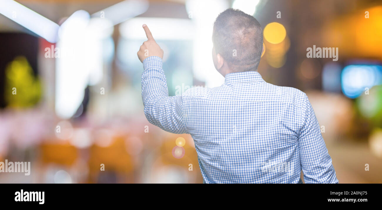 Middle age arab business man over isolated background Posing backwards ...