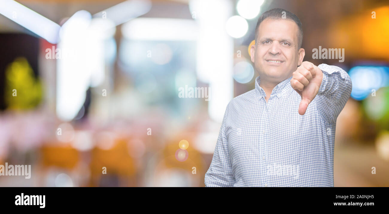 Middle age arab business man over isolated background looking unhappy ...