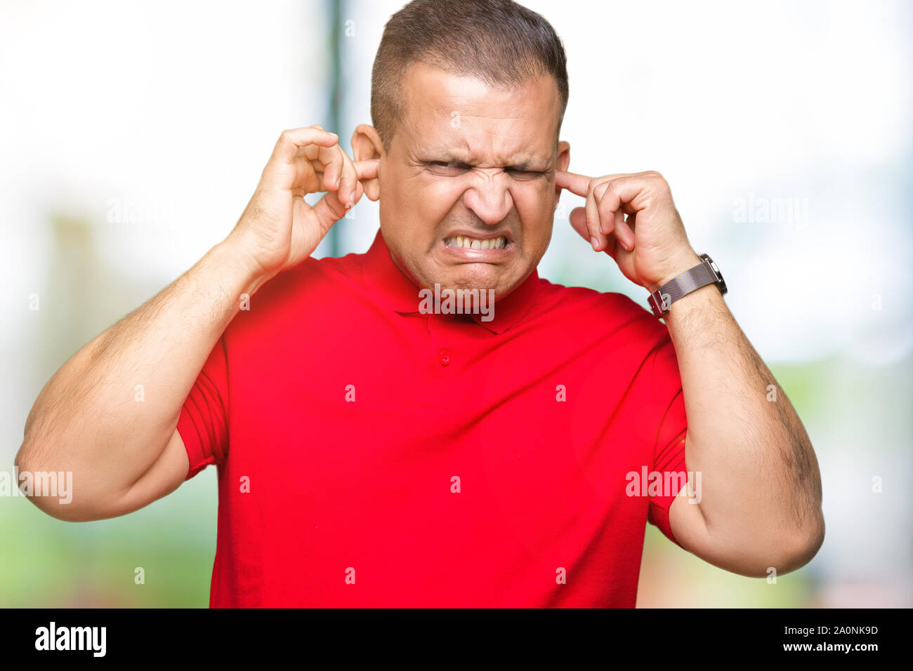 Middle age arab man over isolated background covering ears with fingers ...