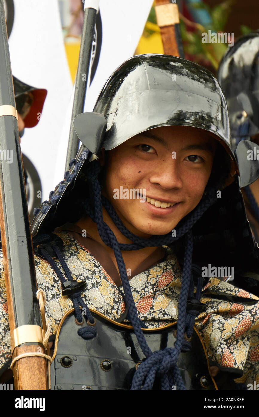 Smiling young Japanese reenactor dressed in traditional samurai costume ...