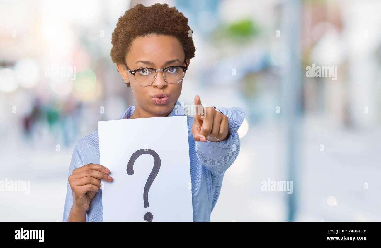Young african american woman holding paper with question mark over ...