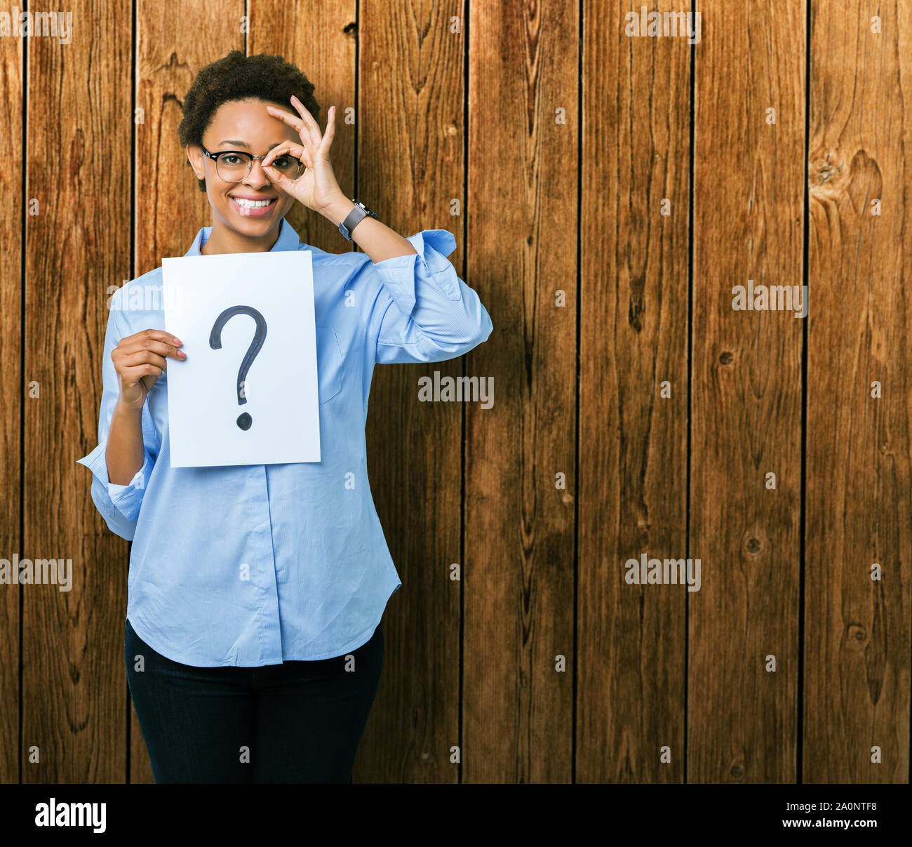 Young african american woman holding paper with question mark over ...