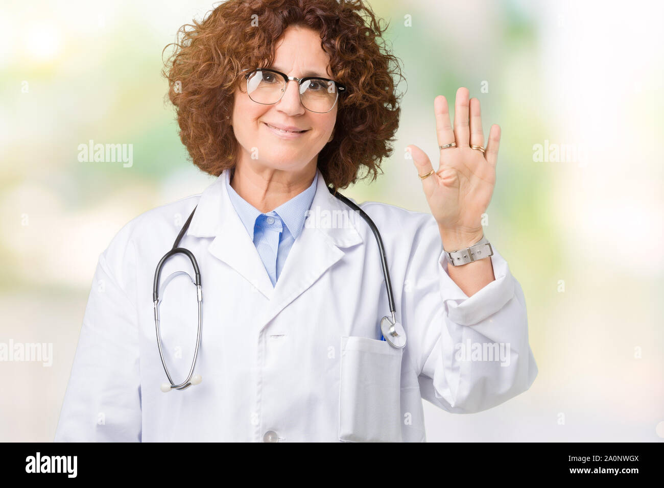 Middle ager senior doctor woman over isolated background Waiving saying ...
