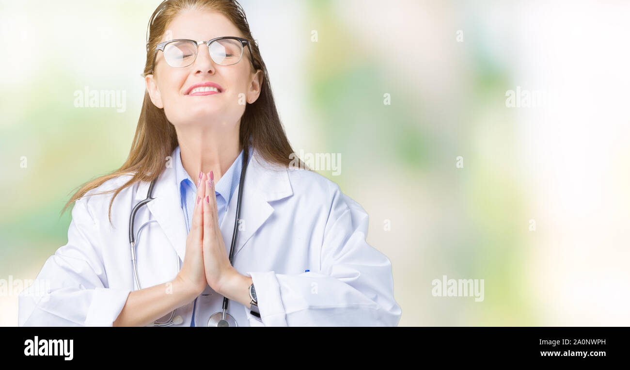 Middle age mature doctor woman wearing medical coat over isolated ...