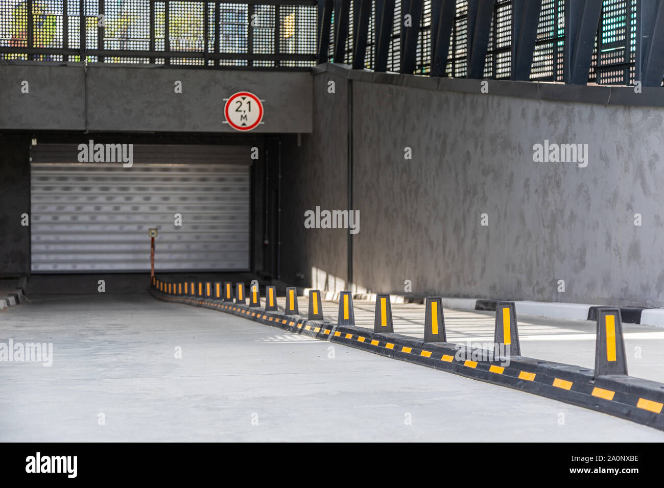 Entrance to underground garage with roller-shutter door and road ...