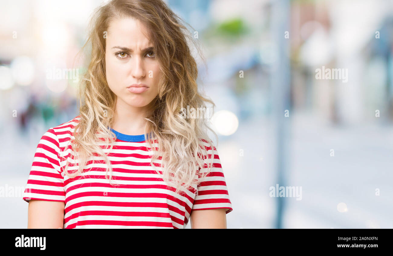Beautiful young blonde woman over isolated background depressed and ...