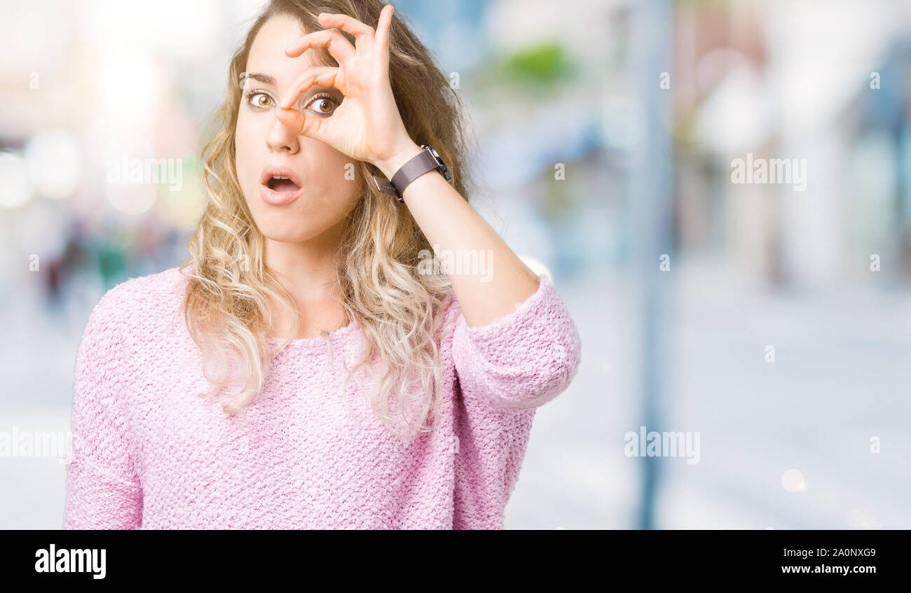 Beautiful young blonde woman over isolated background doing ok gesture ...