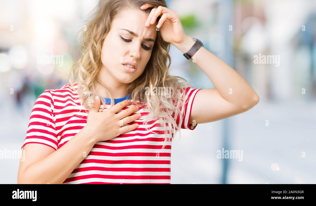 Beautiful young blonde woman over isolated background Touching forehead ...