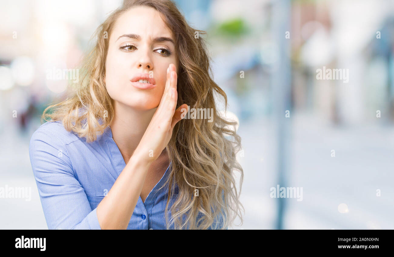Beautiful young blonde business woman over isolated background hand on ... Beautiful young blonde business woman over isolated background hand on ...
