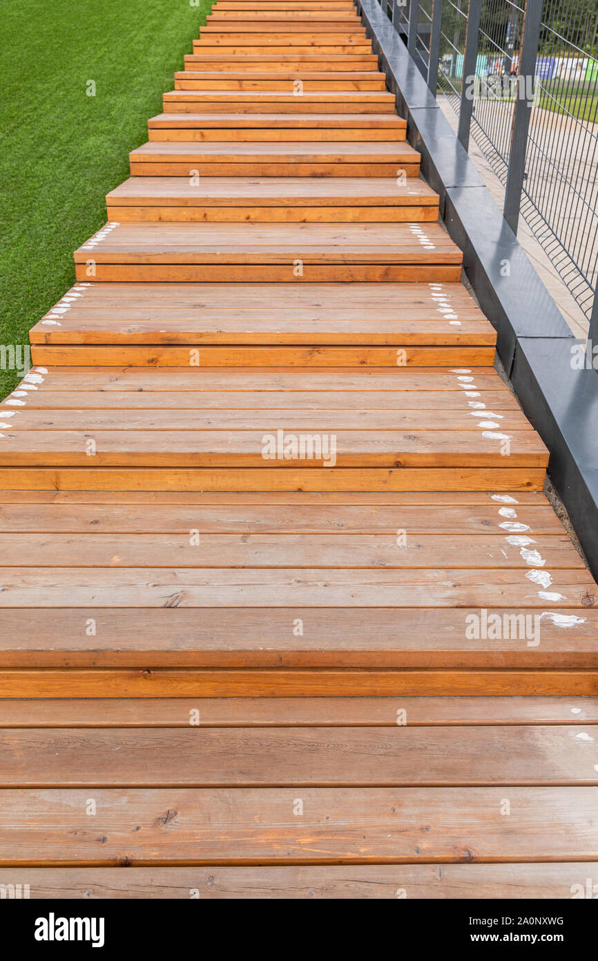 Wooden steps of light color going up near green lawn Stock Photo - Alamy