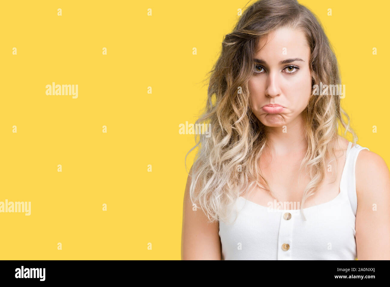 Young beautiful blonde woman over isolated background depressed and ...