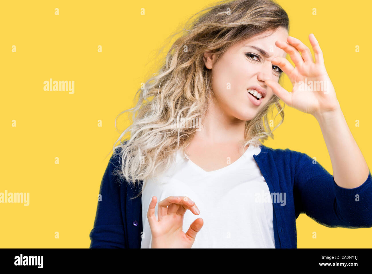 Beautiful young blonde woman over isolated background disgusted ...