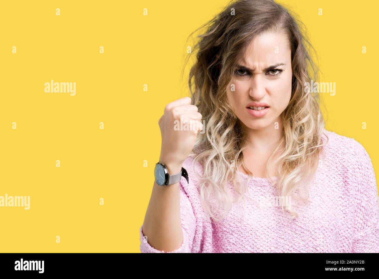 Beautiful young blonde woman over isolated background angry and mad ...