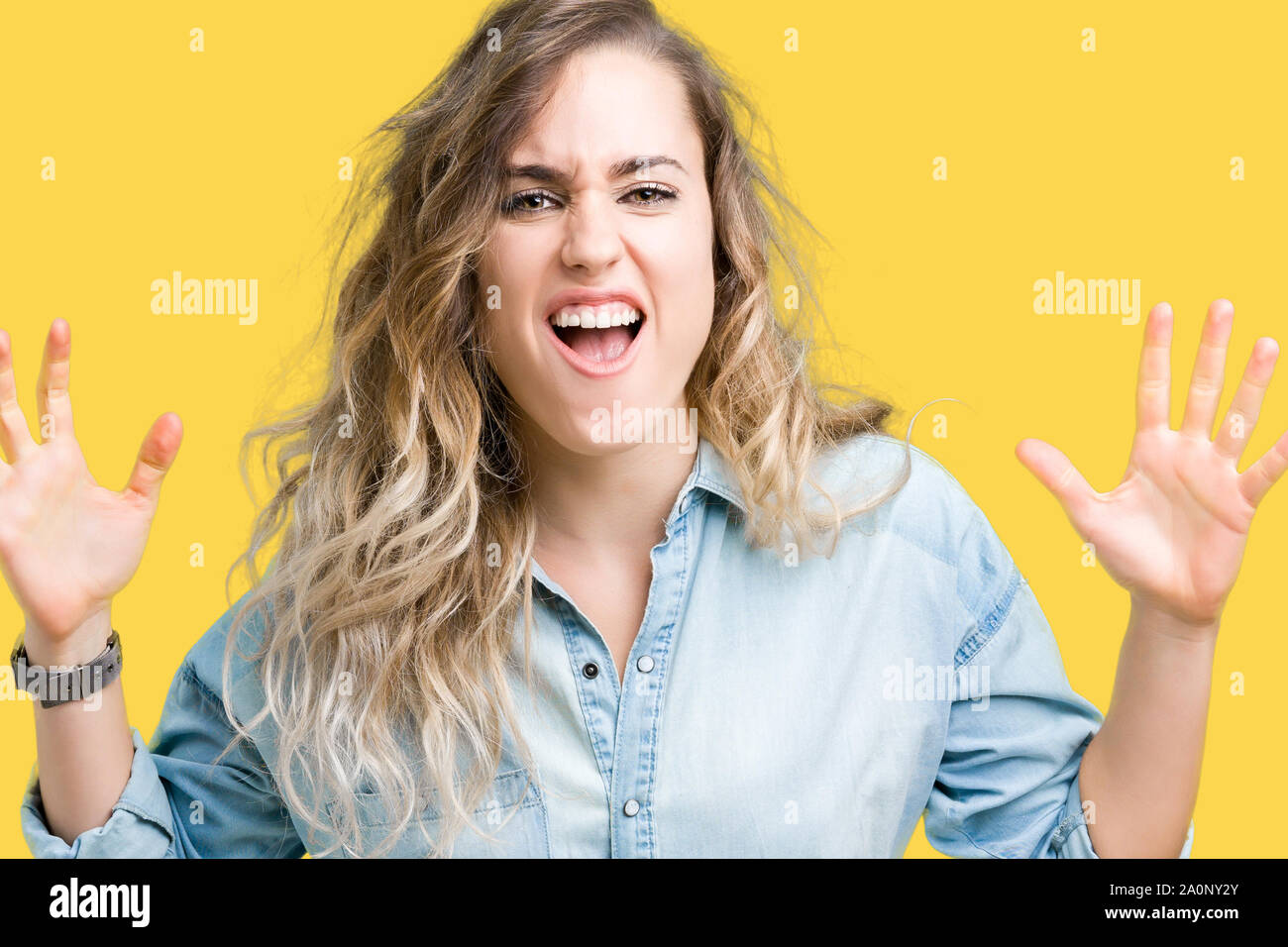 Beautiful young blonde woman over isolated background celebrating crazy ...