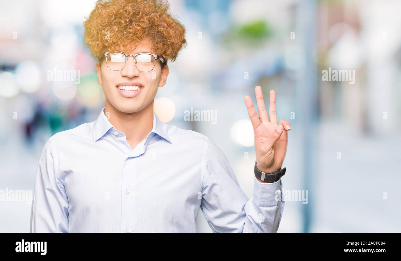 Young handsome business man with afro wearing glasses showing and ...
