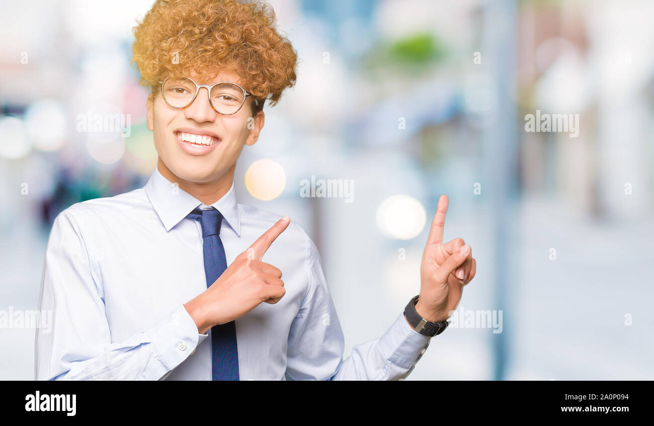 Young handsome business man with afro wearing glasses smiling and ...