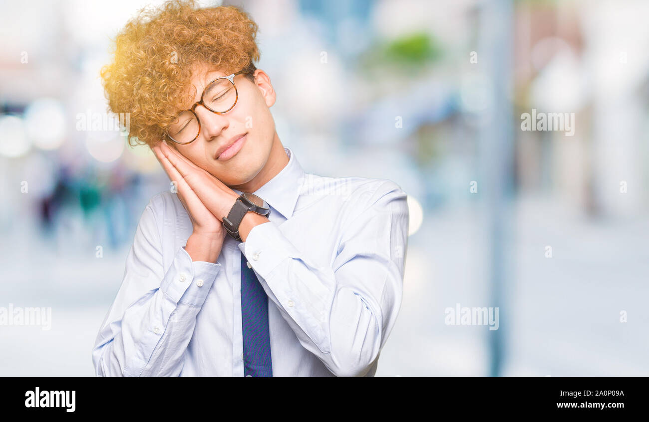 Young handsome business man with afro wearing glasses sleeping tired ...