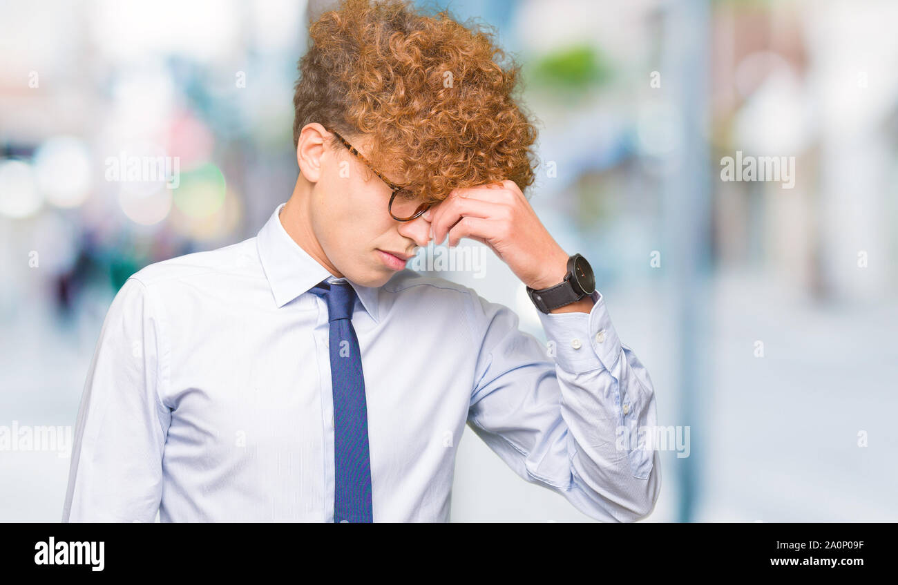 Young handsome business man with afro wearing glasses tired rubbing ...