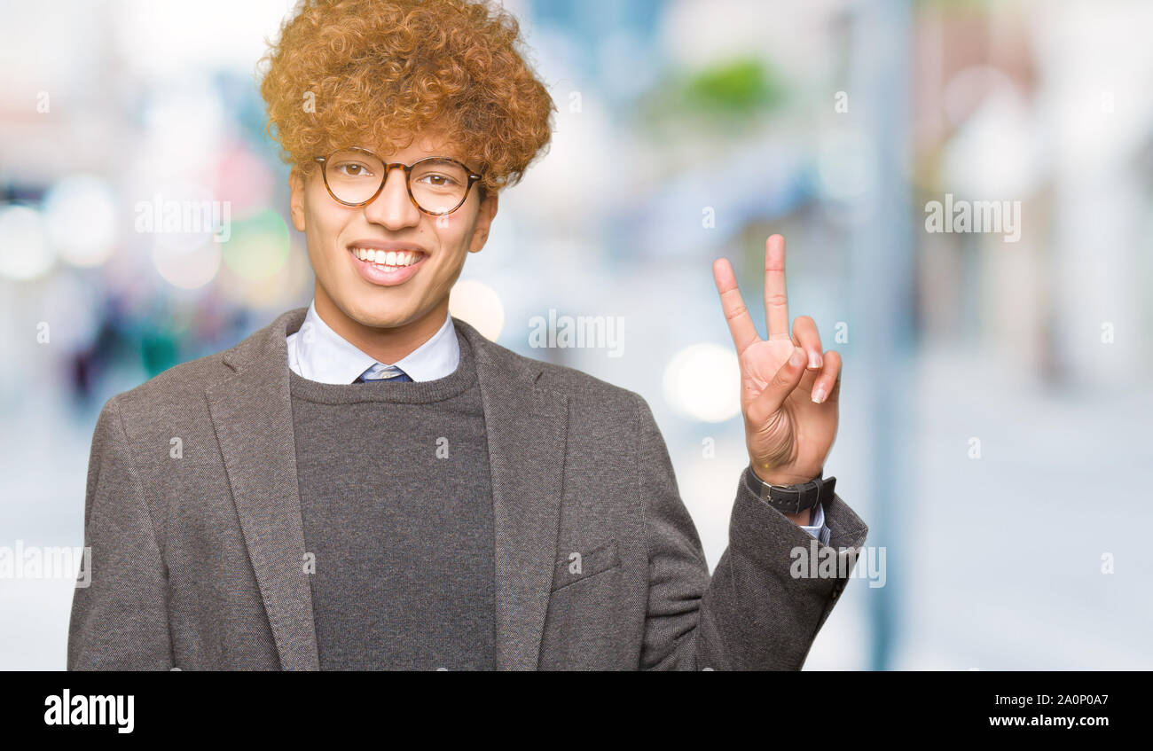 Young handsome business man with afro wearing glasses smiling with ...