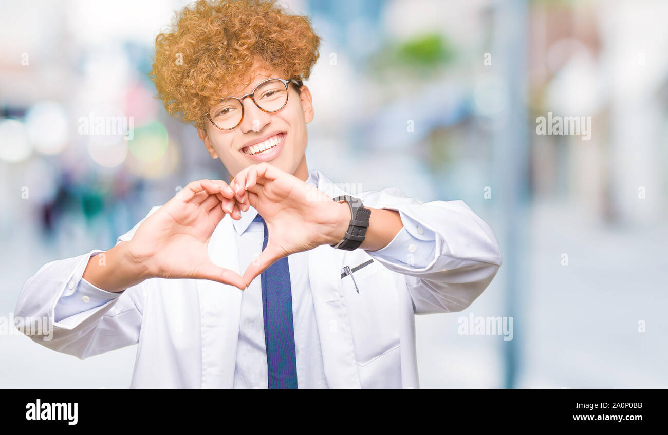 Young handsome scientist man wearing glasses smiling in love showing ...