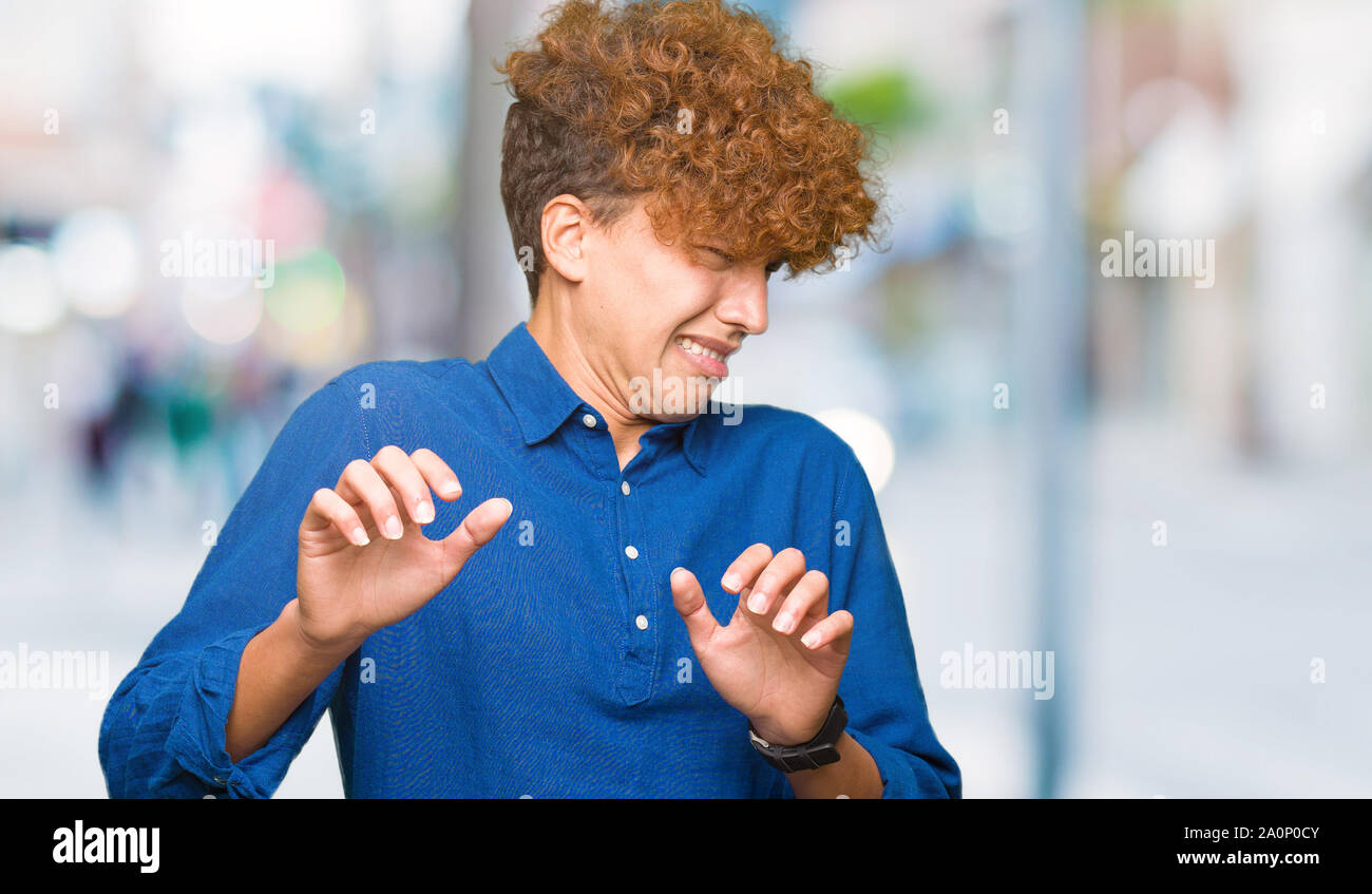 Young handsome elegant man with afro hair disgusted expression ...