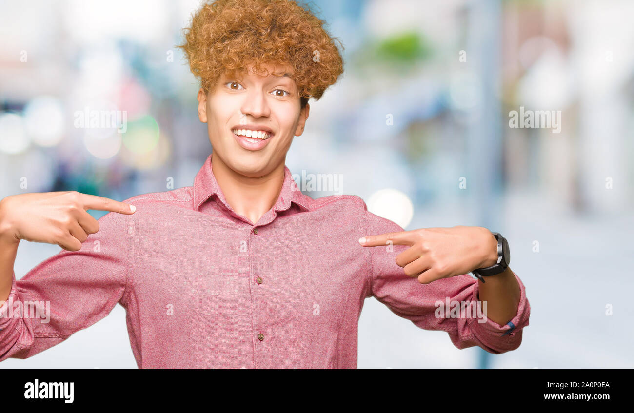 Young handsome business man with afro hair looking confident with smile ...