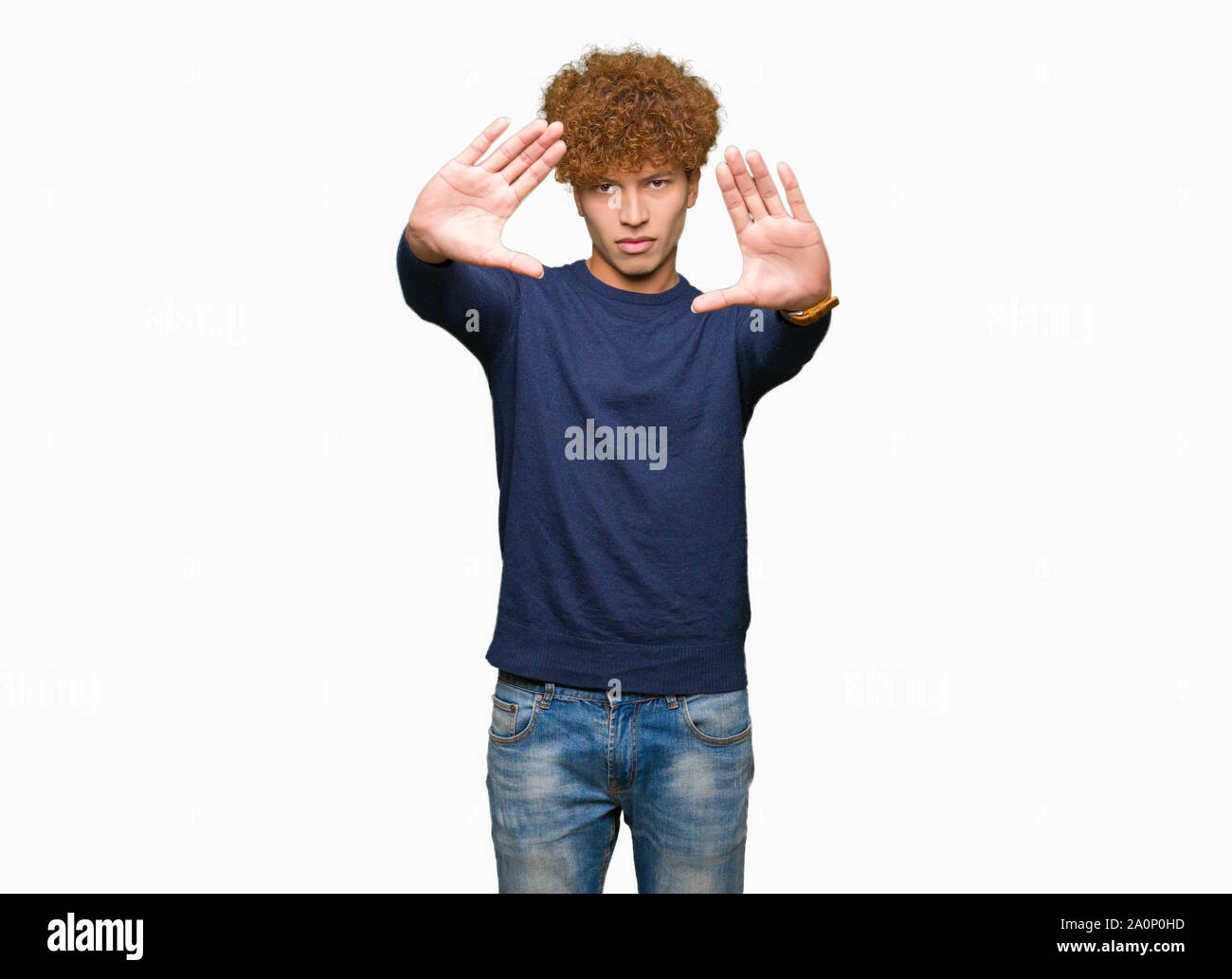 Young handsome man with afro hair Smiling doing frame using hands palms ...