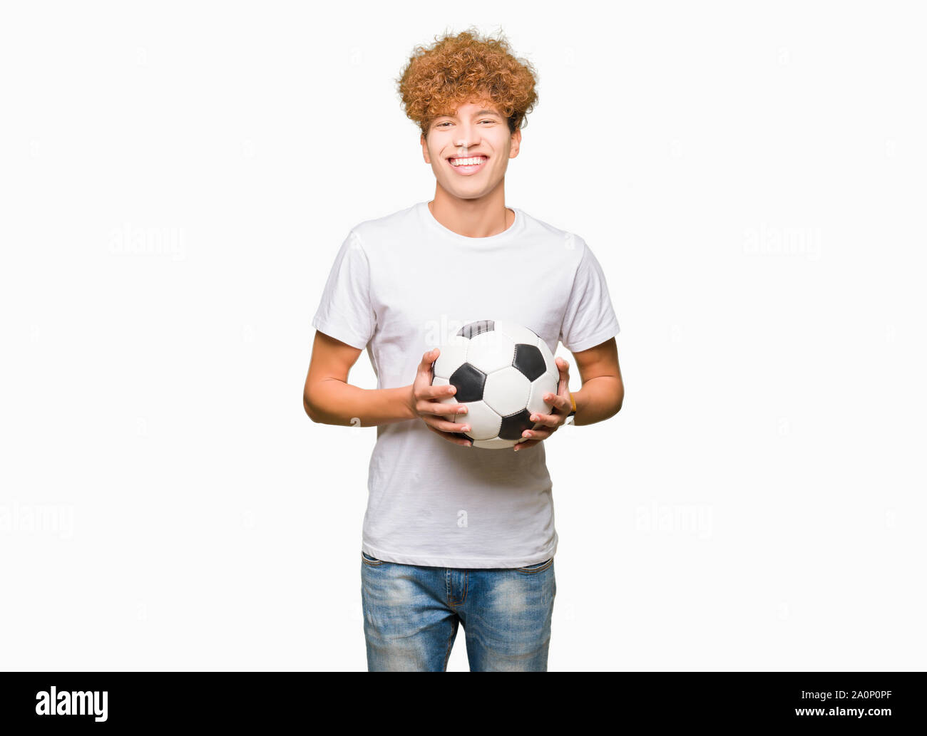 Young handsome man holding soccer football ball with a happy face ...