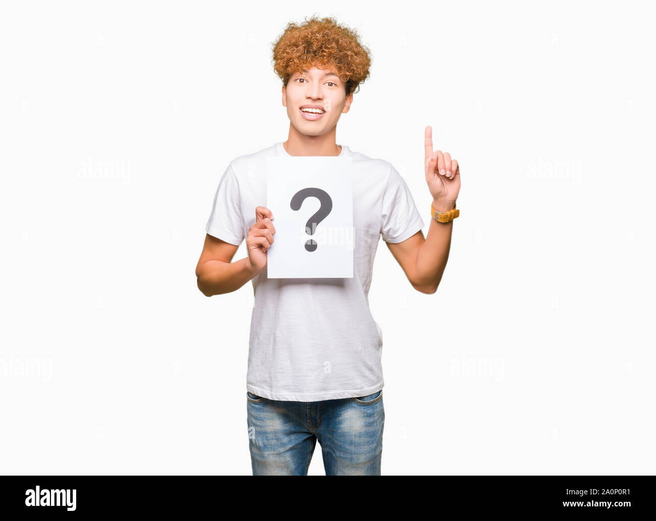 Young handsome man holding paper with question mark surprised with an ...