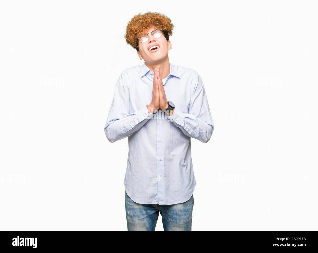 Young handsome business man with afro wearing glasses begging and ...