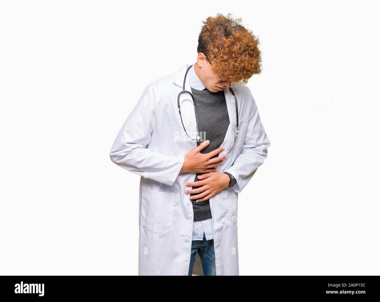 Young handsome doctor man wearing medical coat with hand on stomach ...